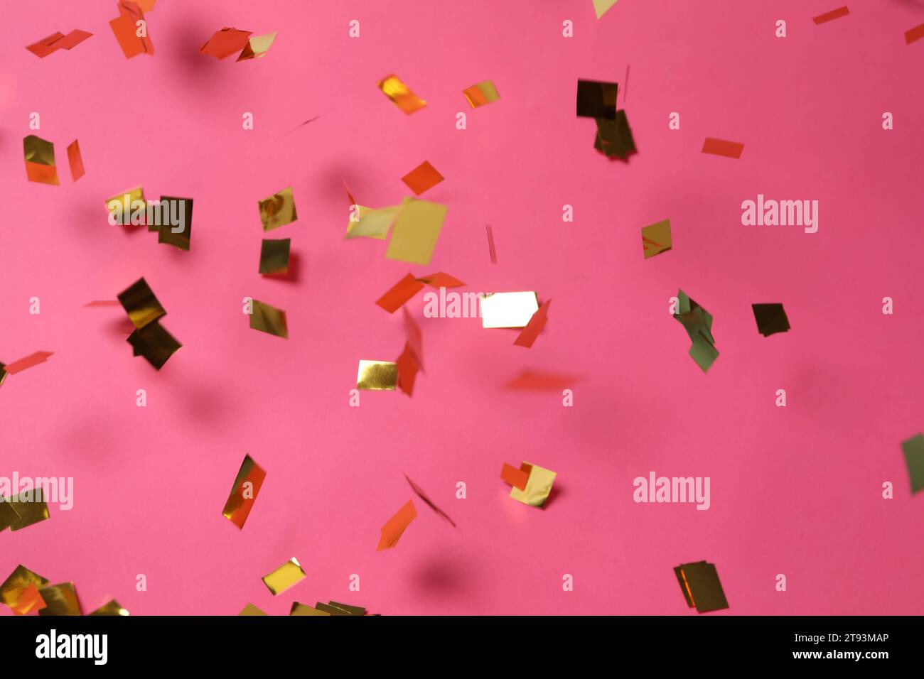 Shiny golden confetti falling down on pink background Stock Photo - Alamy