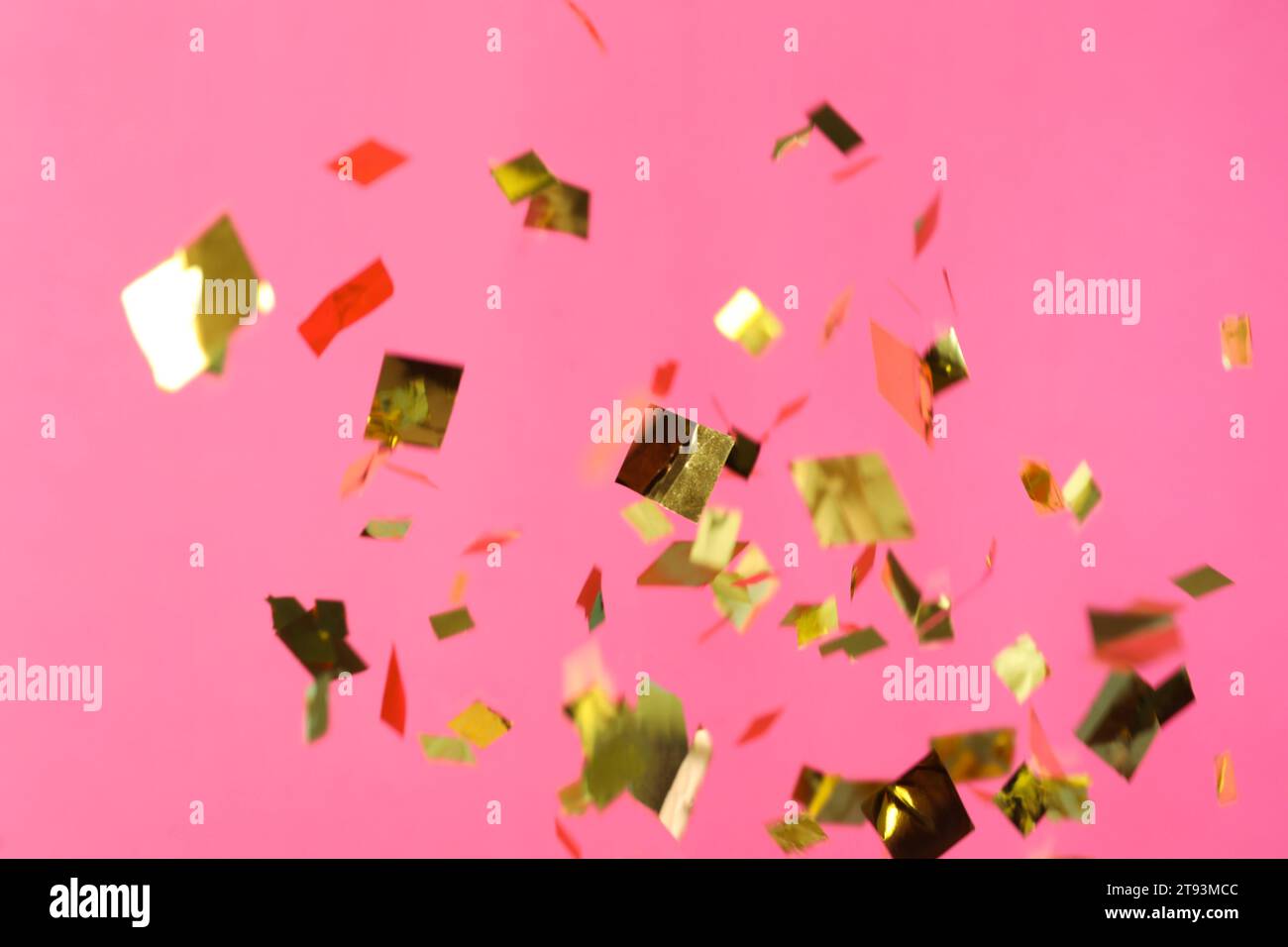 Shiny golden confetti falling down on pink background Stock Photo - Alamy