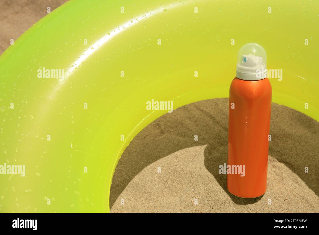 Sunscreen and inflatable ring on sand. Sun protection care Stock Photo ...