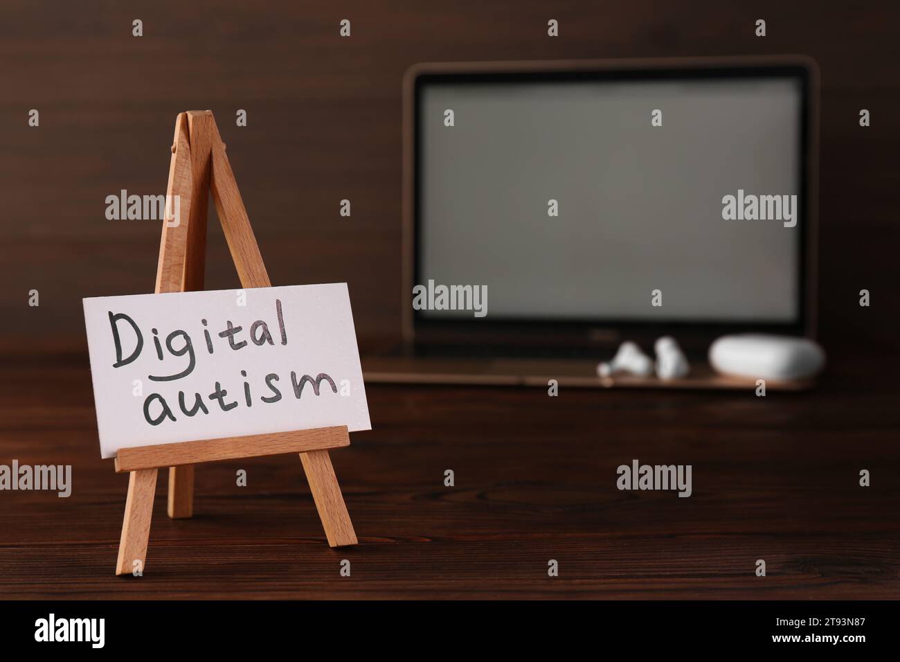 Card with phrase Digital Autism and laptop on wooden table, selective ...