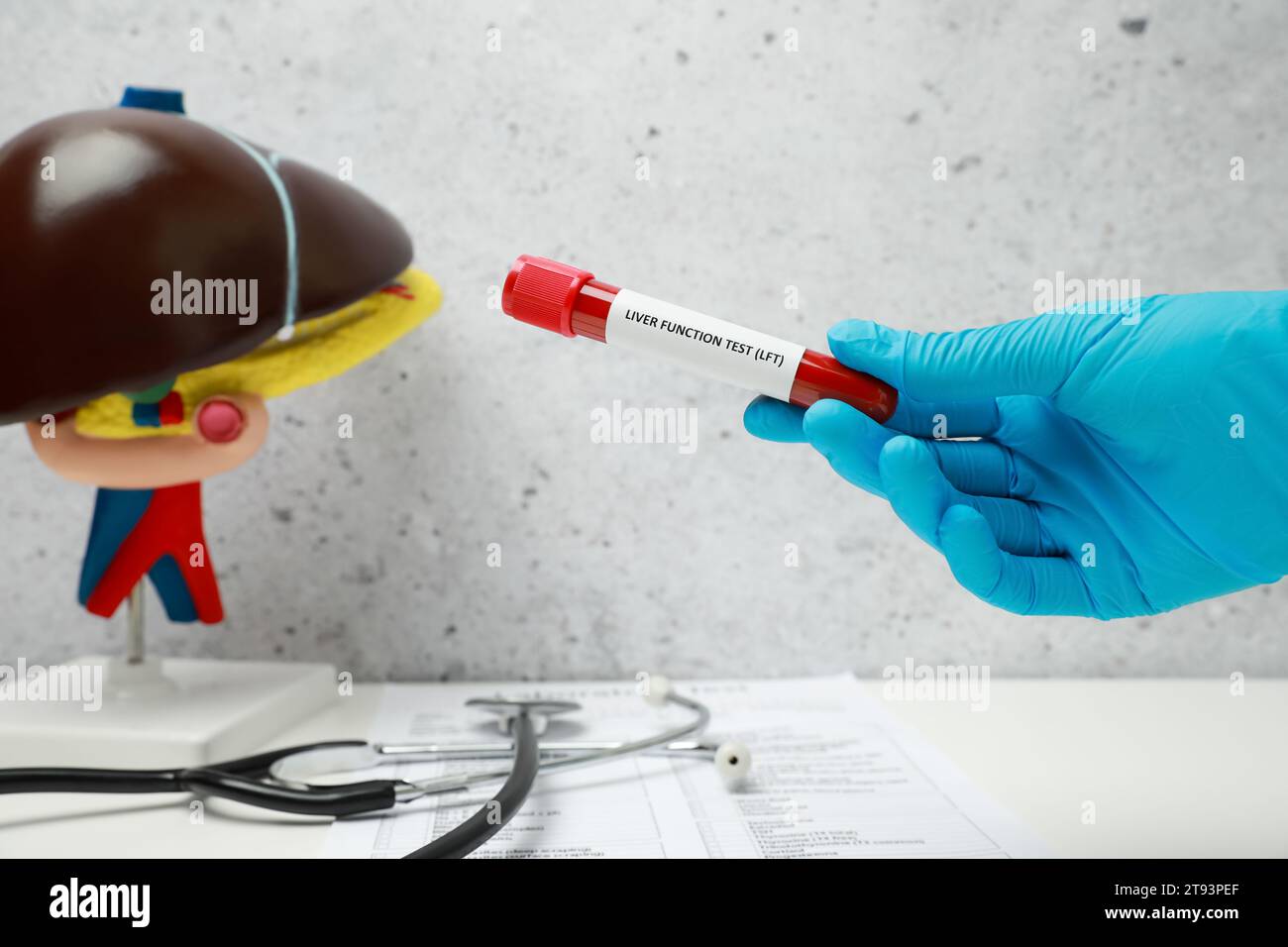 Laboratory worker holding tube with blood sample and label Liver ...