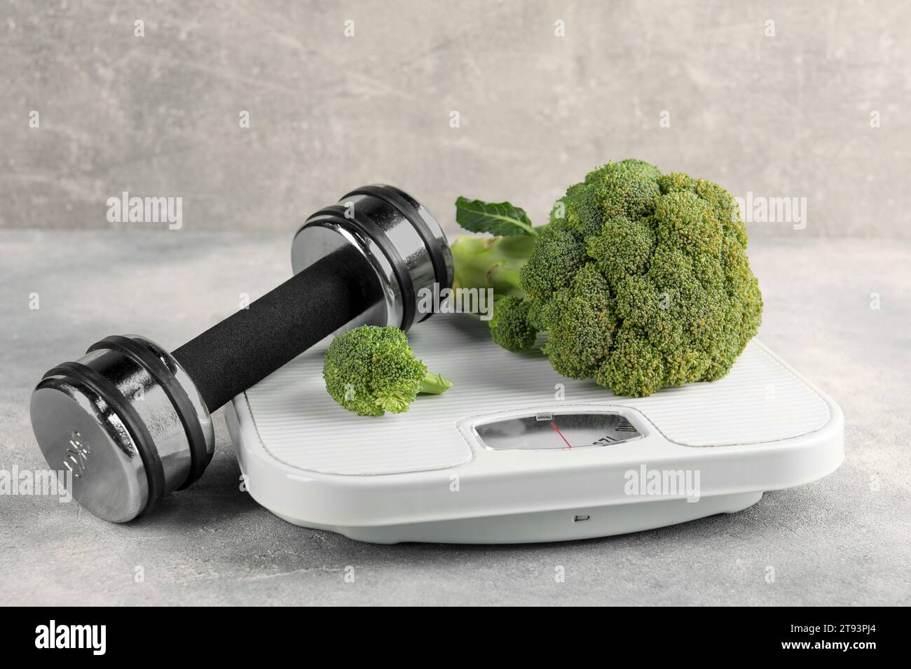 Healthy diet. Scale, broccoli and dumbbell on grey table Stock Photo ...