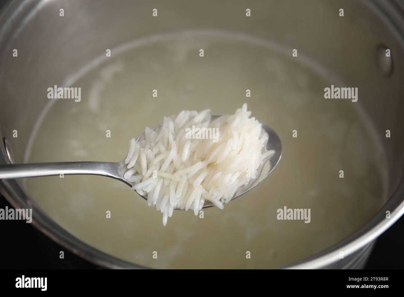 Spoon with cooked rice over pot, closeup Stock Photo - Alamy