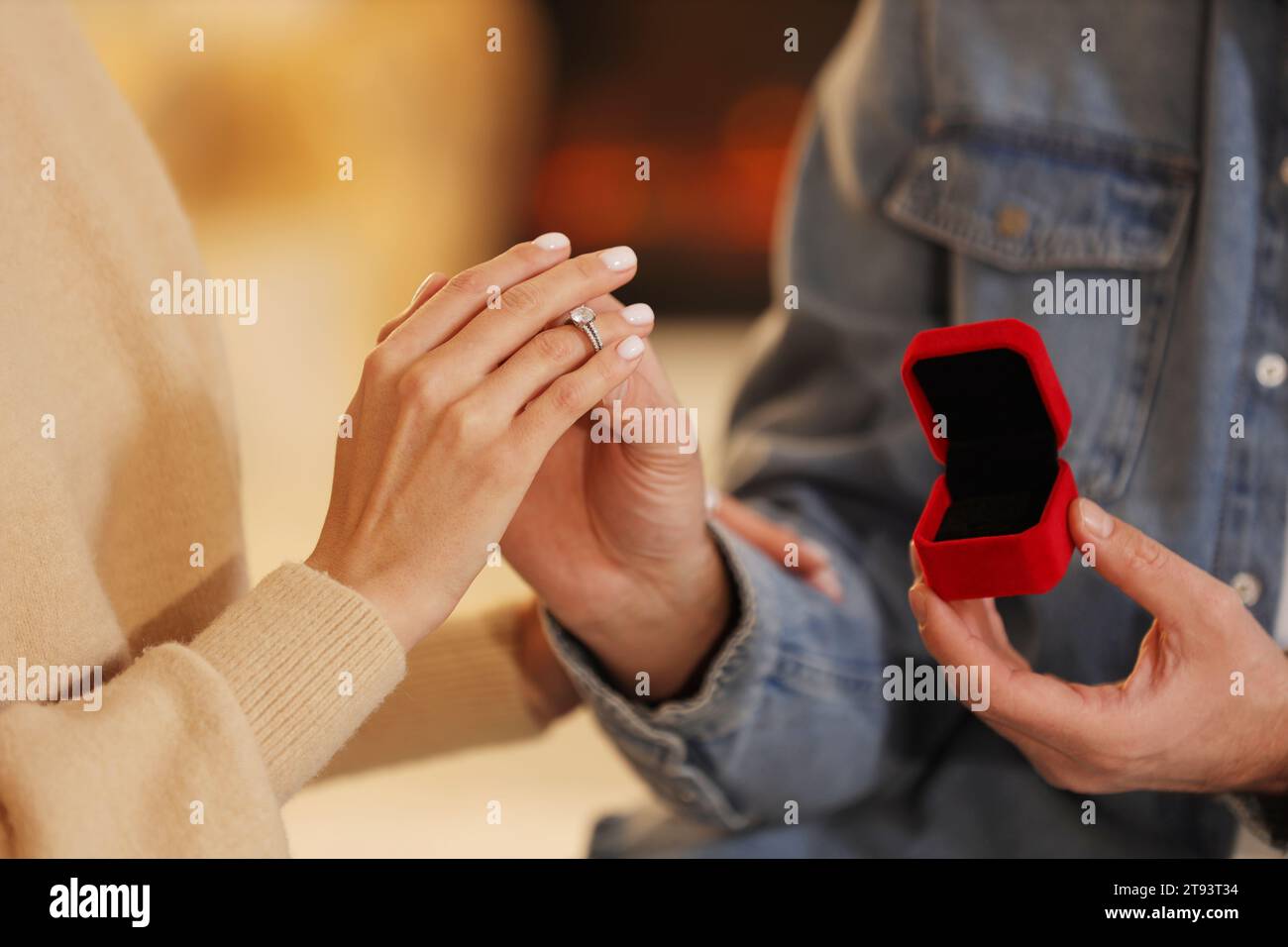 Making proposal. Man putting engagement ring on his girlfriend's finger ...