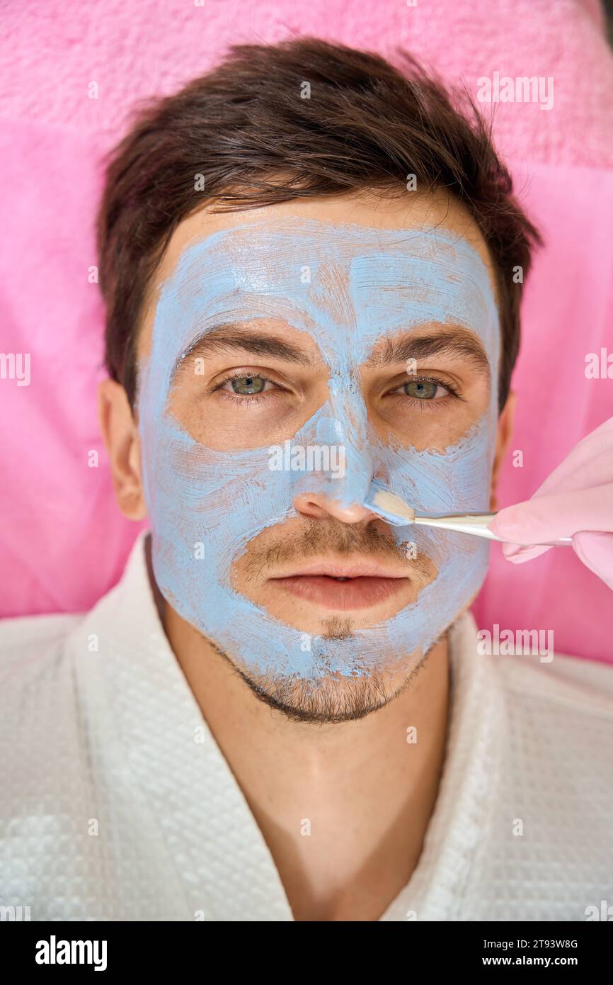 Man gets a face mask done in aesthetic medicine clinic Stock Photo - Alamy