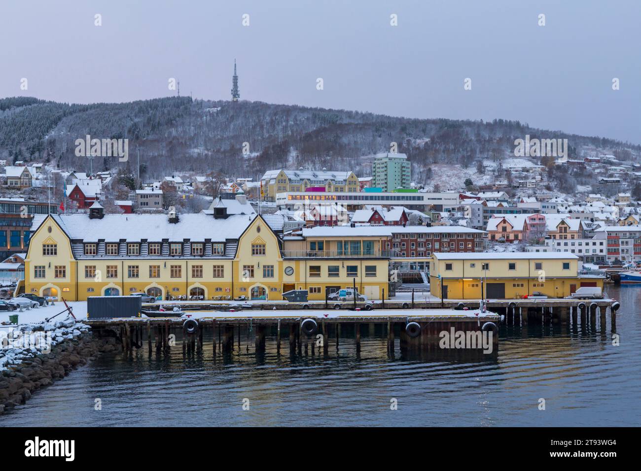 Buildings along waterfront harbour in the snow at Harstad, Norway ...