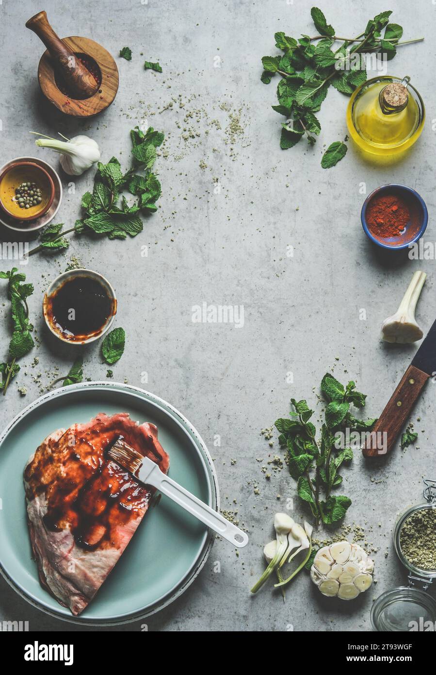 Raw marinated lamb on plate at kitchen table with mint, spices, garlic ...