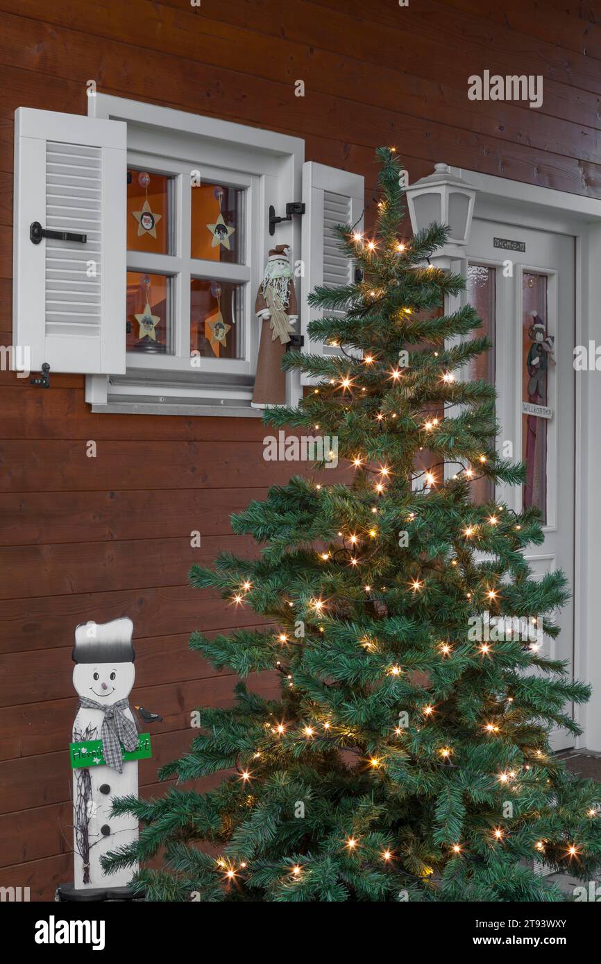 Decorated christmas tree, outside in front of a wooden house Stock ...