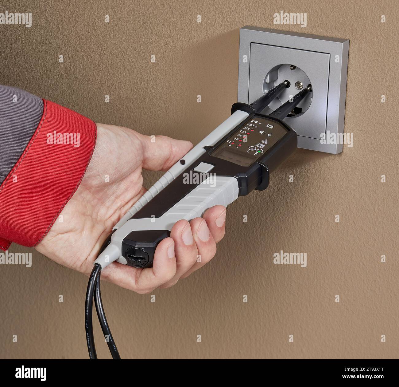 Electrician measuring the voltage in the socket with a professional digital multimeter, one ...