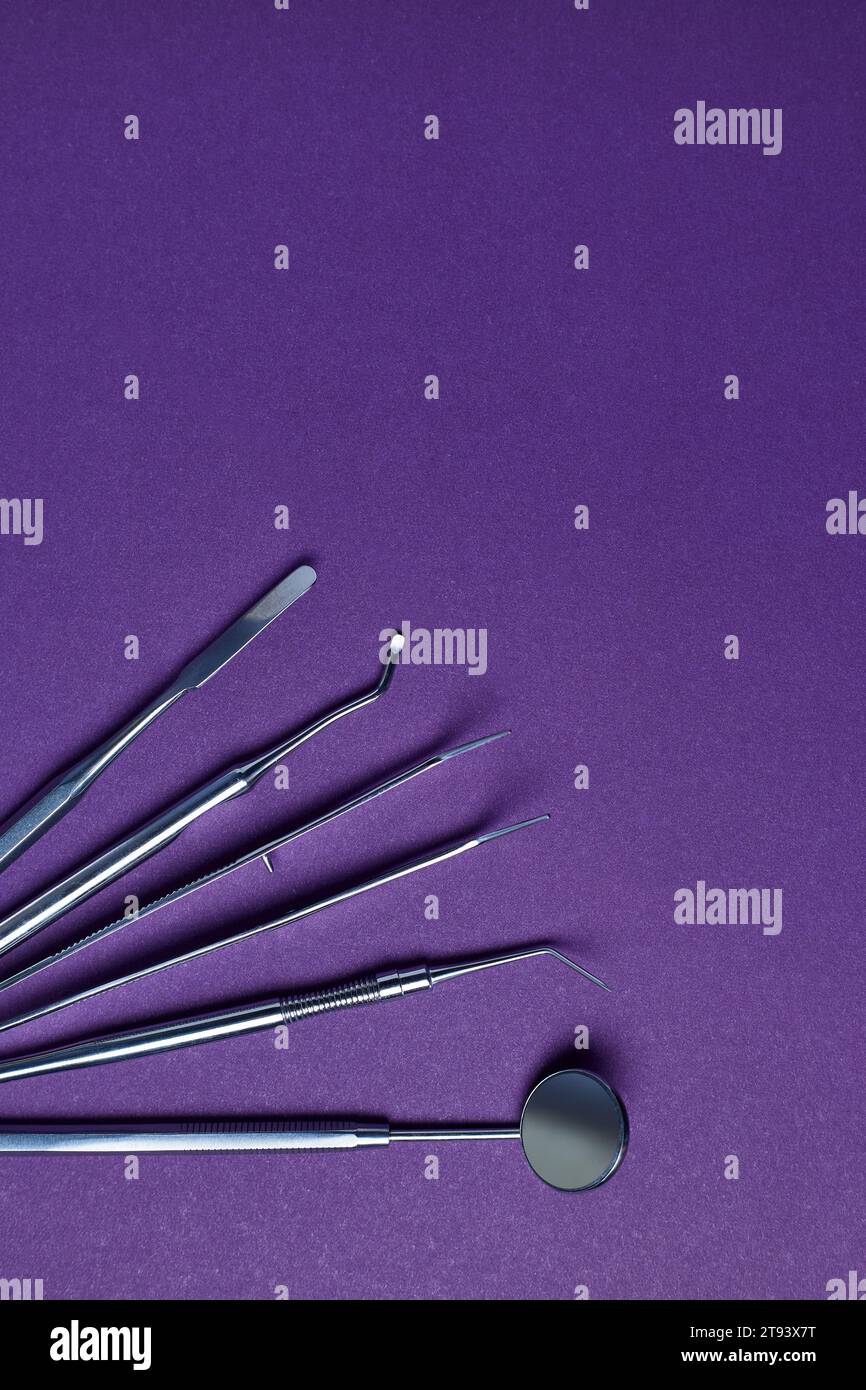 Dental tools on violet background Stock Photo - Alamy