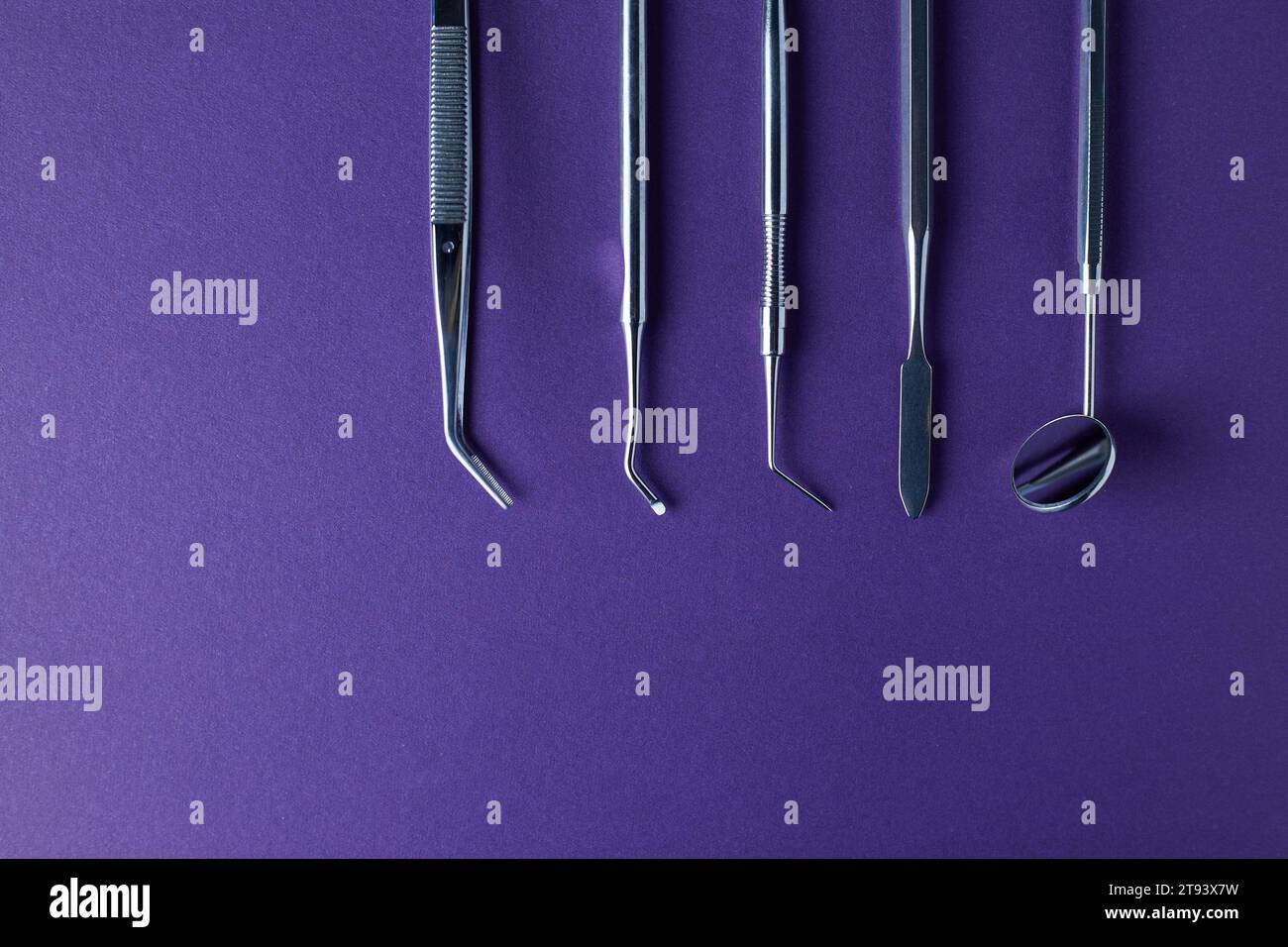 Dental tools on violet background Stock Photo - Alamy