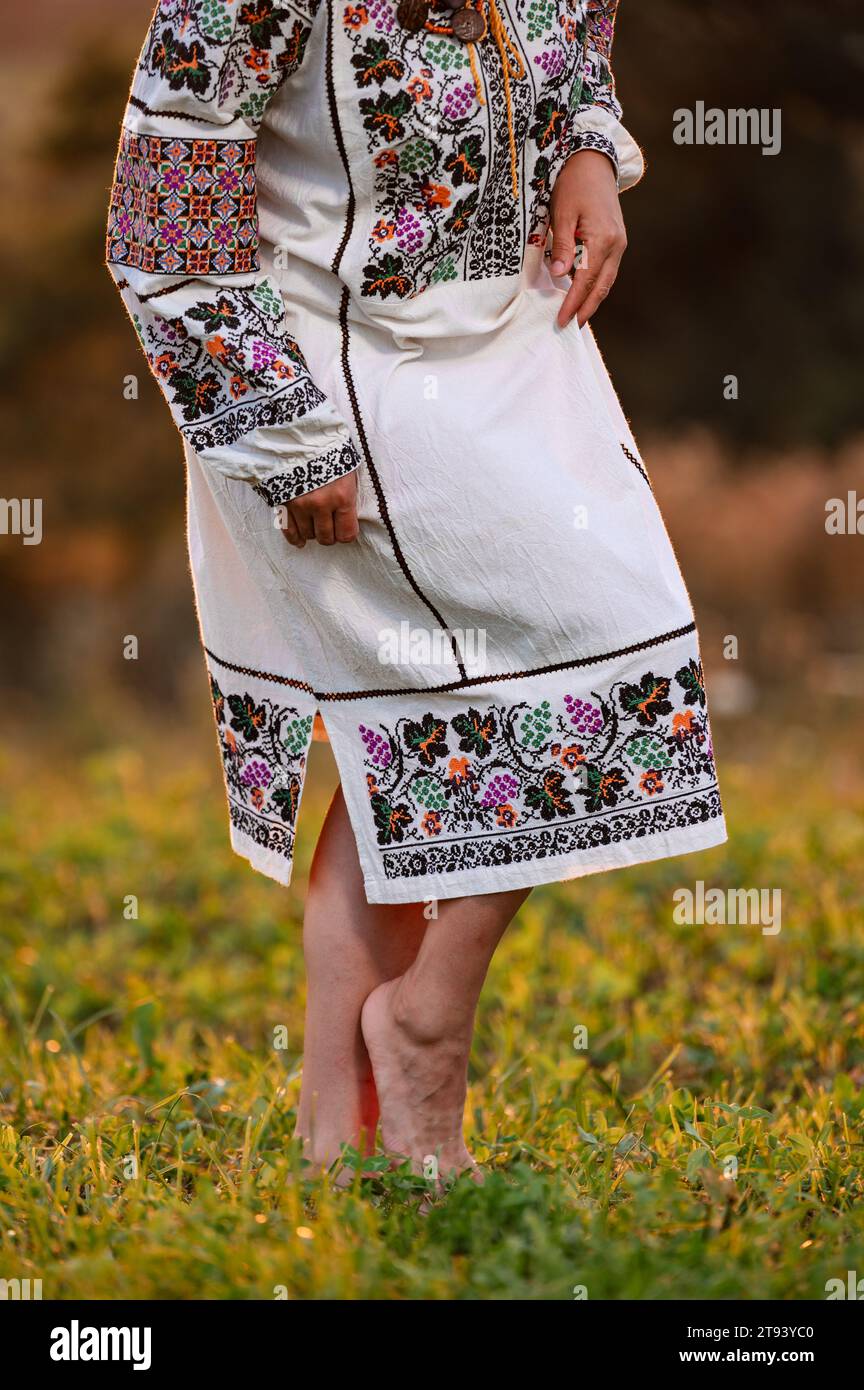 Embroidered and unique petticoat, a girl walks barefoot in the field in ...