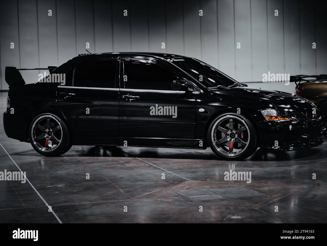 A Black Mitsubishi Evo parked at a car show, surrounded by other ...