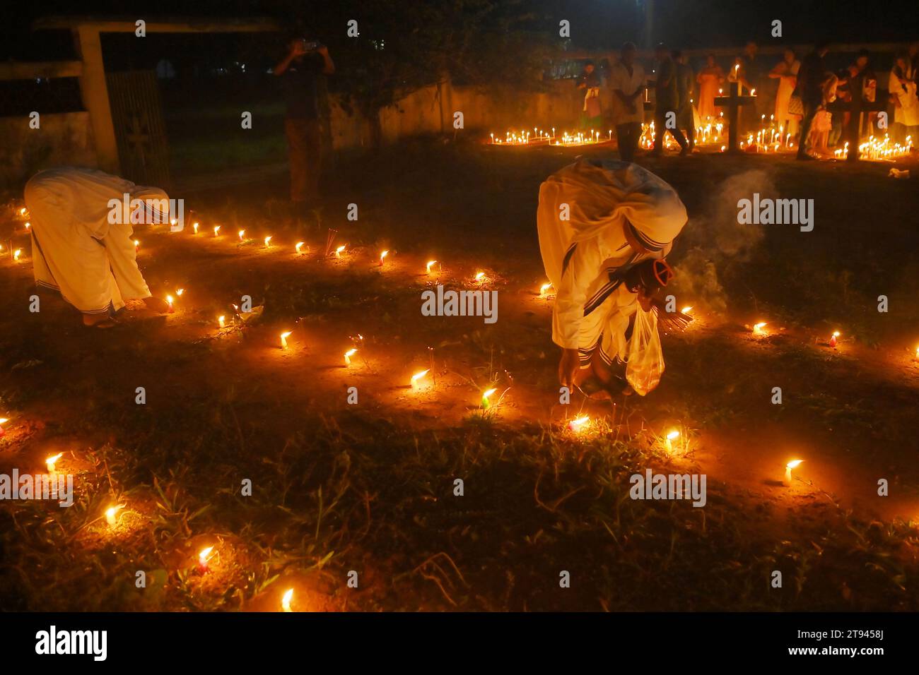 Nuns offer prayers next to the graves of their family members at a ...