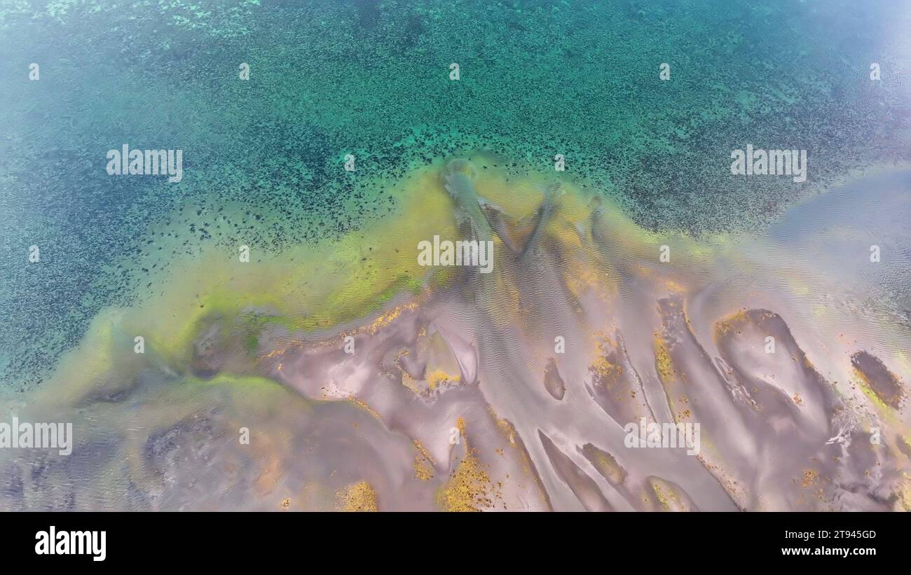Aerial view of patterns of Icelandic rivers flowing into the ocean ...