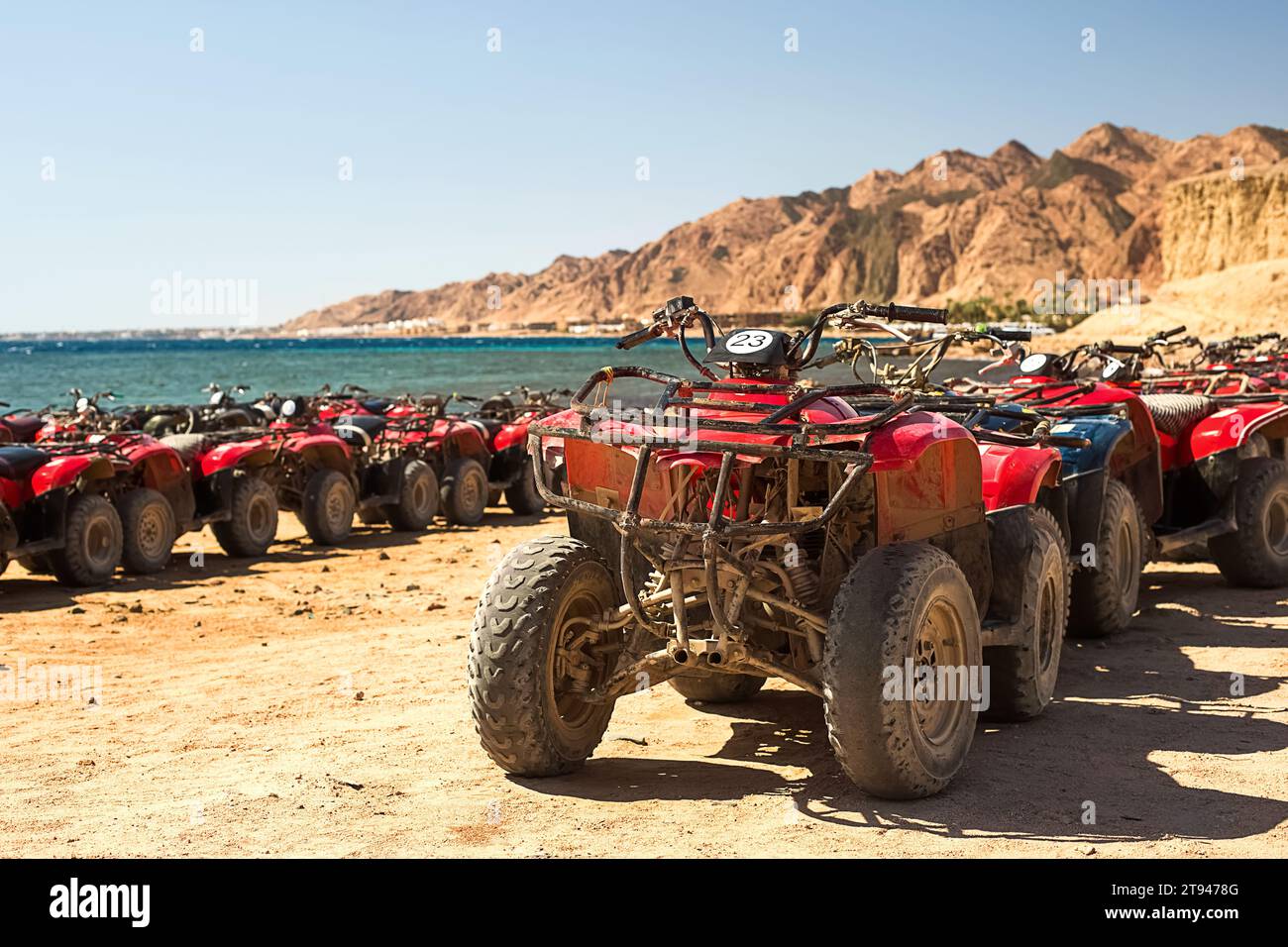 Red quads stand in a row on the shore of the Red Sea. Dahab, Egypt ...