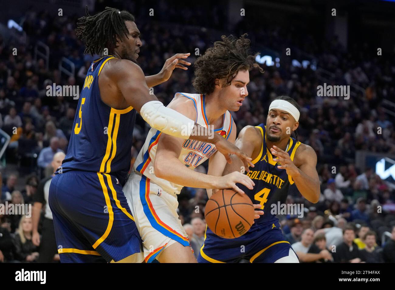 Oklahoma City Thunder guard Josh Giddey, middle, is defended by Golden State Warriors forward ...