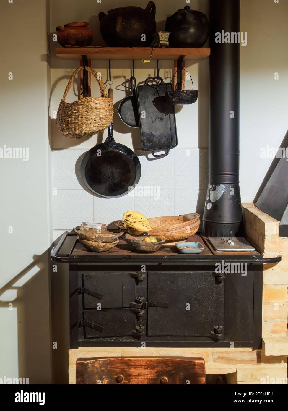 View of a firewood iron stove and some kitchen utensils in a farm house ...