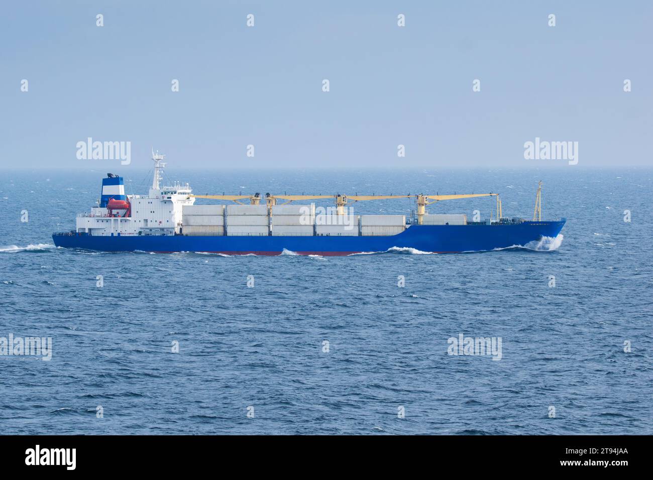 A blue cargo ship with containers on deck Stock Photo - Alamy