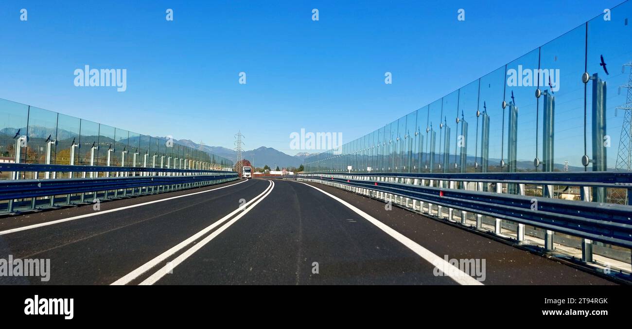 long sound-absorbing noise barrier of transparent glass on the highway ...