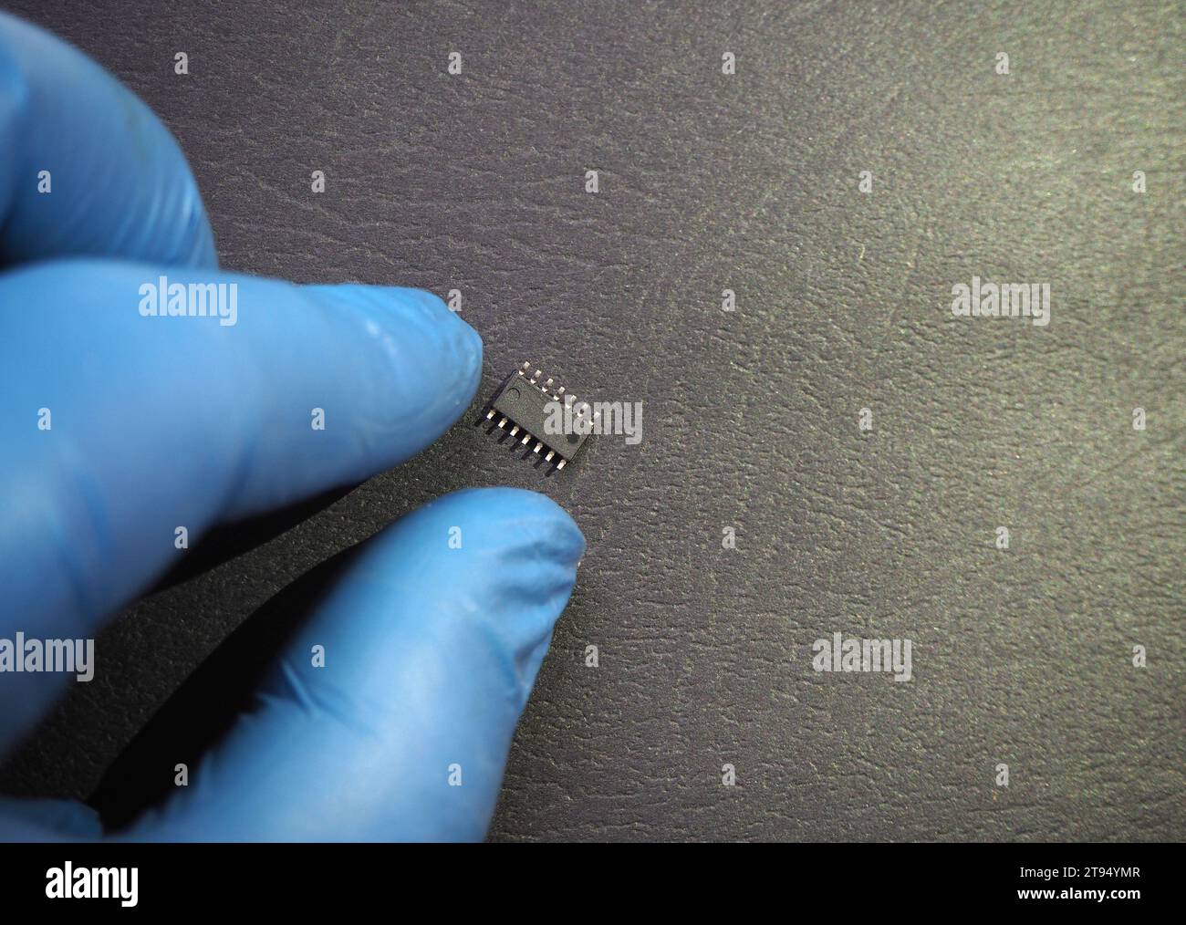 Semiconductor industry. Hand holding an electronic micro chip. 14 pins ...