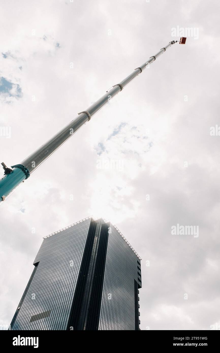 A large blue truck crane stands ready for operation on a site near a ...