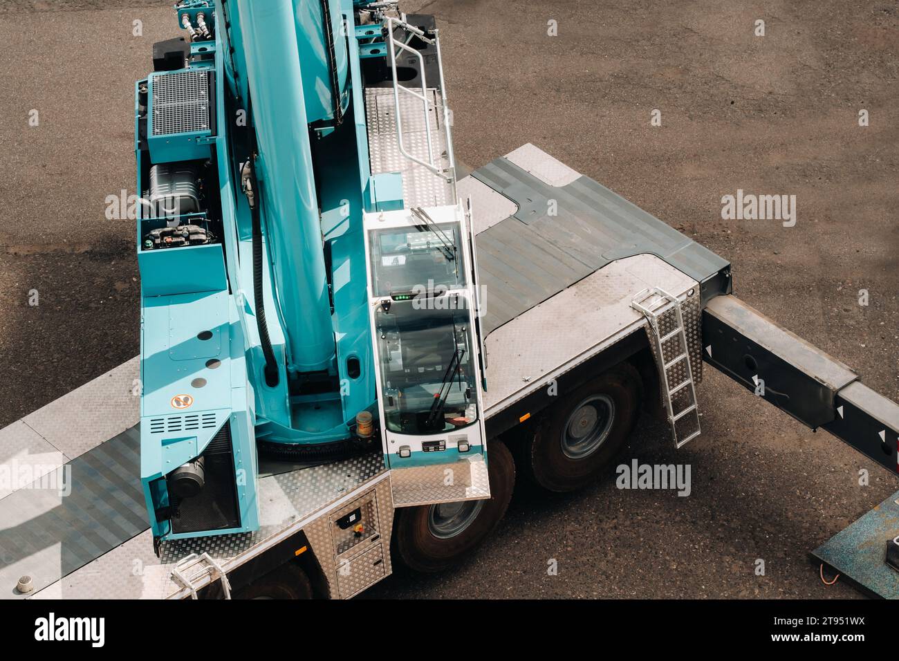 a cab with the operator of a Large blue car crane that stands ready to ...