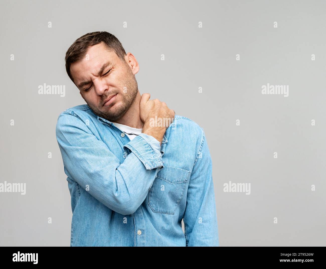 Neck pain or cervicalgia. Man touching his neck with his hand and ...