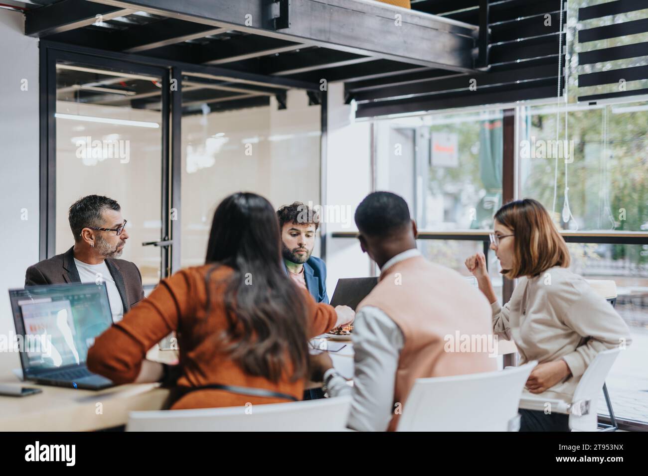 Cross generational business group collaborates in a modern office ...