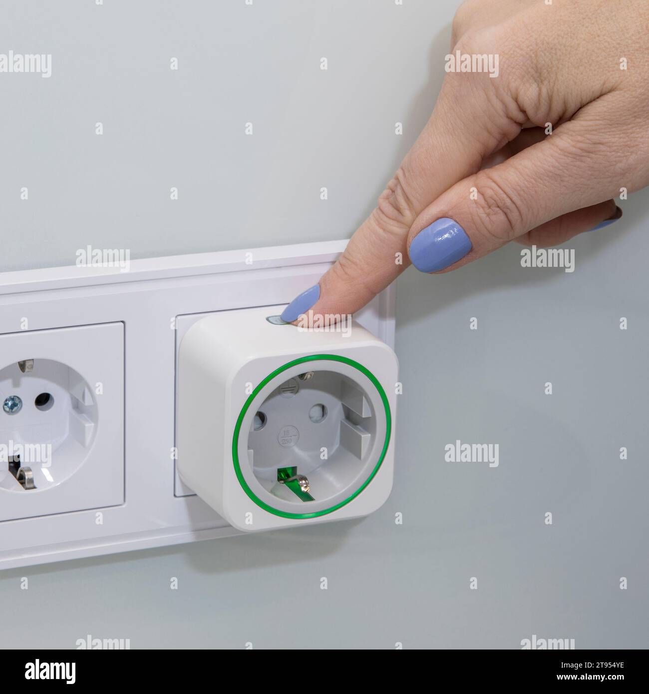 Finger on a wireless extension switch in wall mounted plug Stock Photo ...