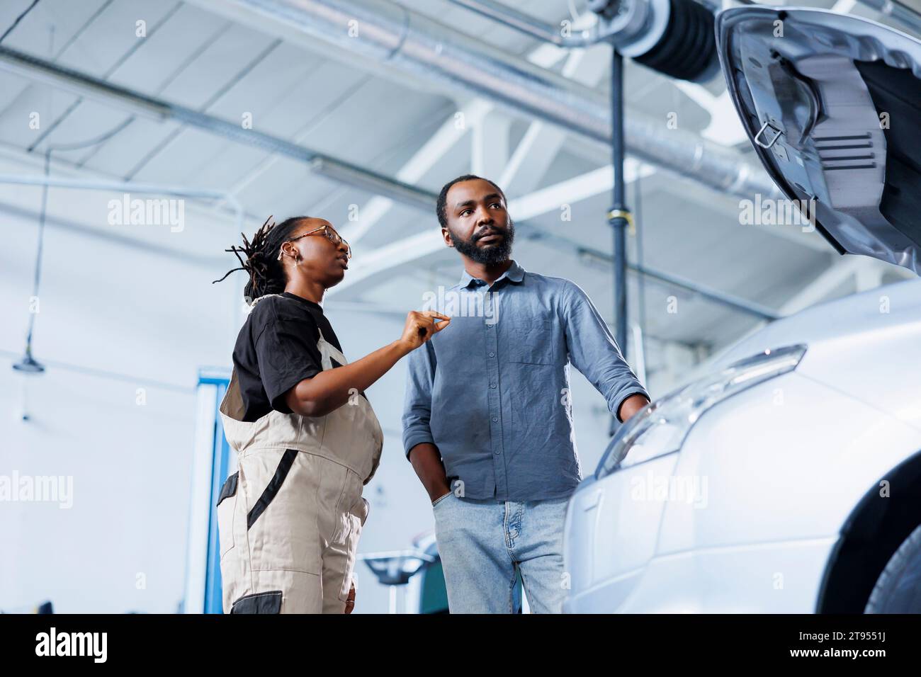Professional in repair shop using AR technology to show man defective ...
