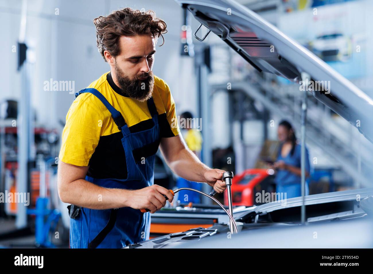 Certified engineer using oil extractor tool to change old transmission ...