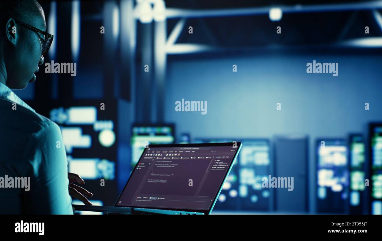 Manager overseeing data center, running code on laptop, troubleshooting and upgrading ...