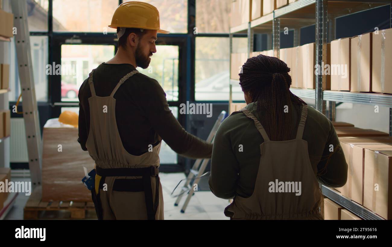 Meticulous employee walking through warehouse aisles scanning cardboard ...