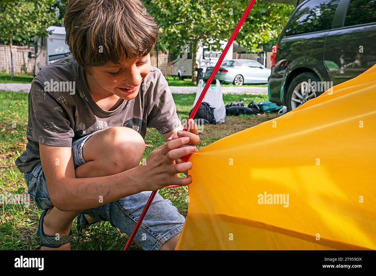happy boy setting up a tent at a camping camp. Family holidays and ...