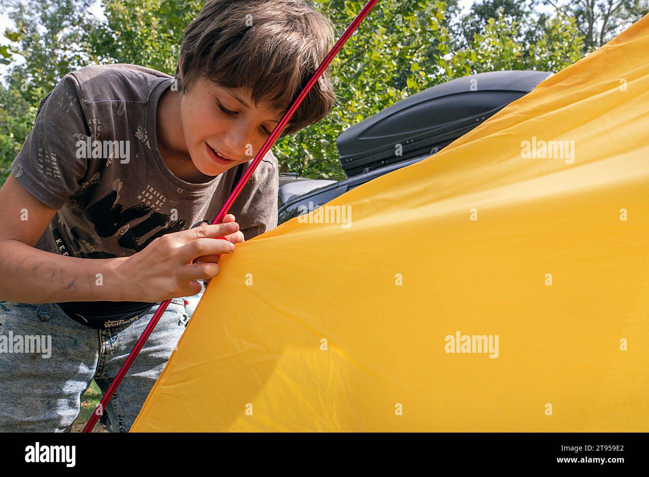 happy boy setting up a tent at a camping camp. Family holidays and ...
