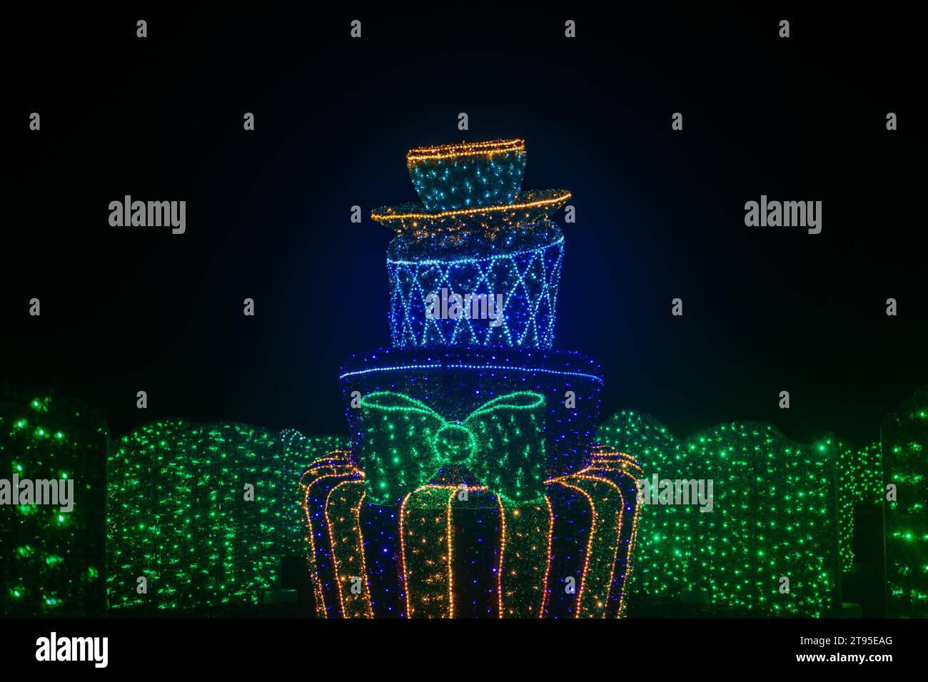 Christmas installation.Glowing cake object in the dark.Multitiered cake ...