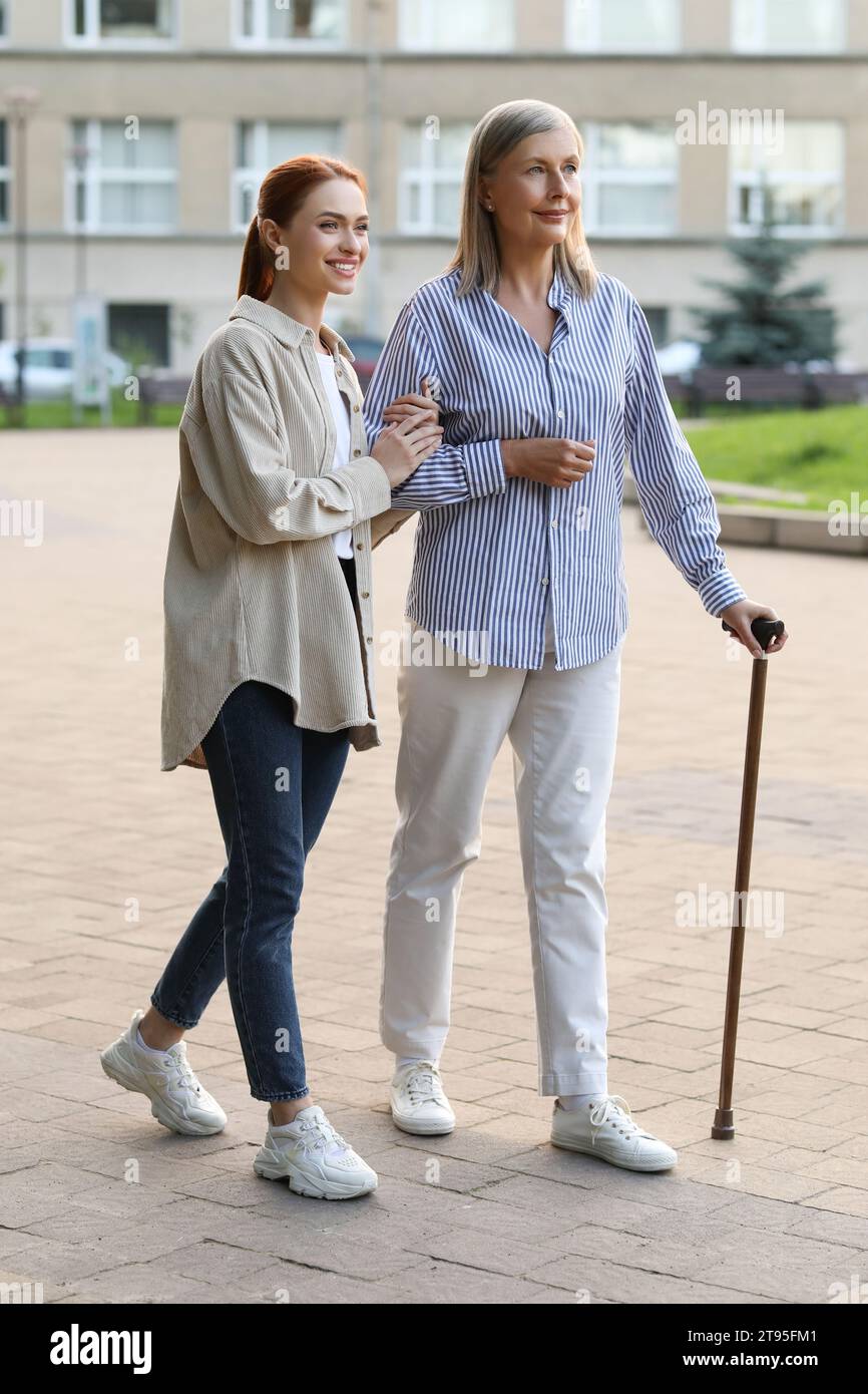 Senior lady with walking cane and young woman outdoors Stock Photo - Alamy