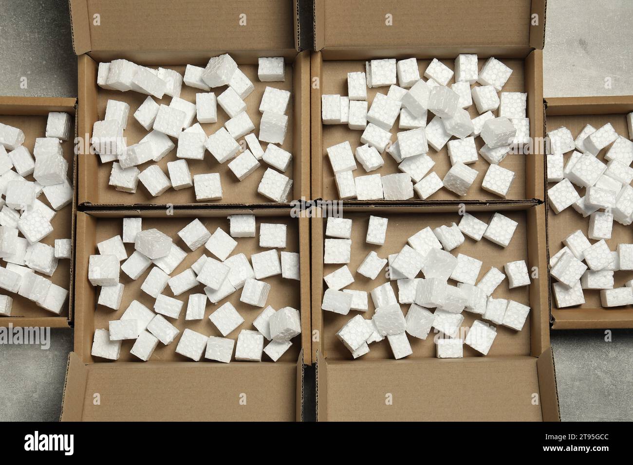 Many open cardboard boxes with pieces of polystyrene foam on grey ...