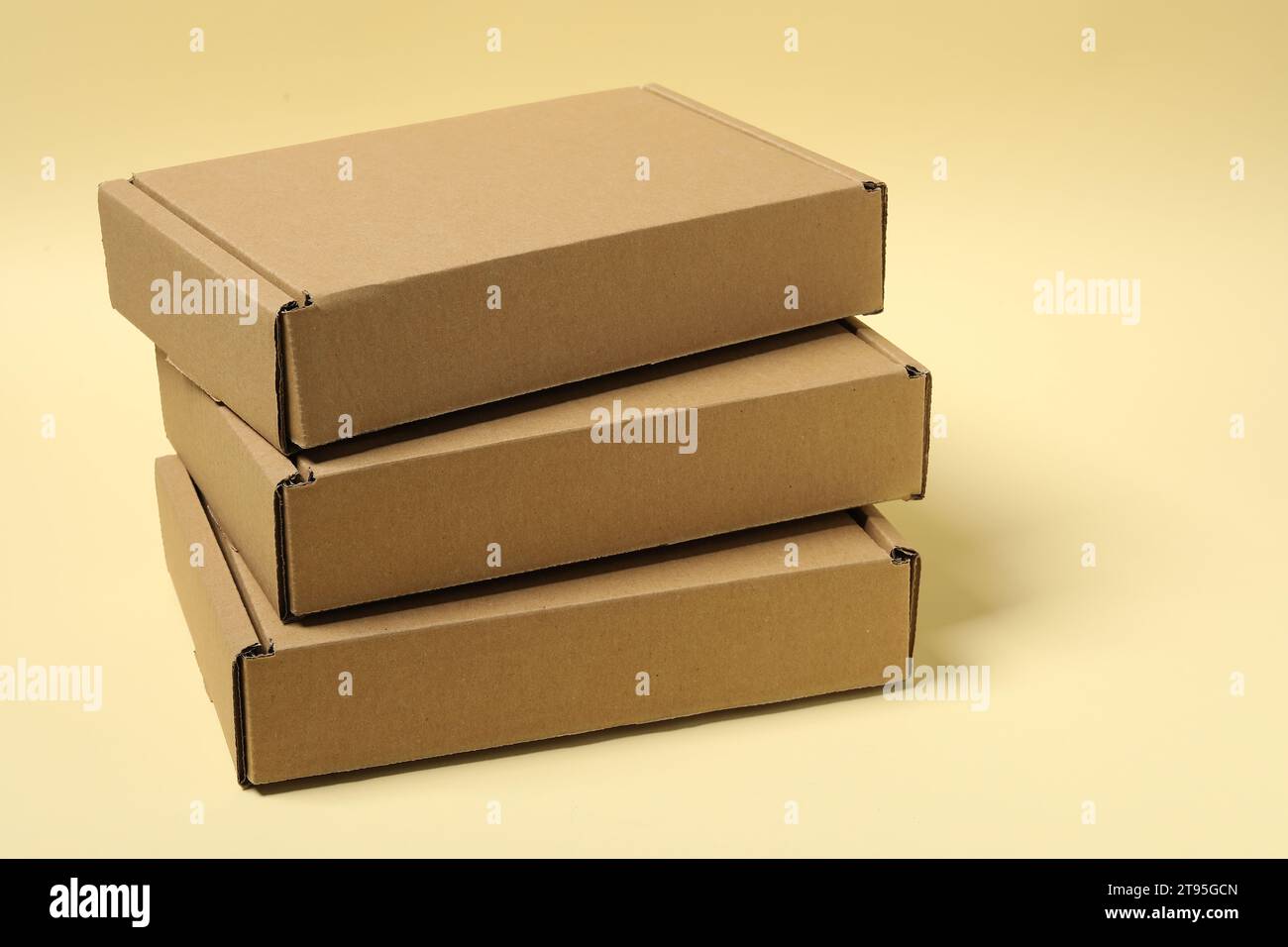 Stack of closed cardboard boxes on pale yellow background Stock Photo ...