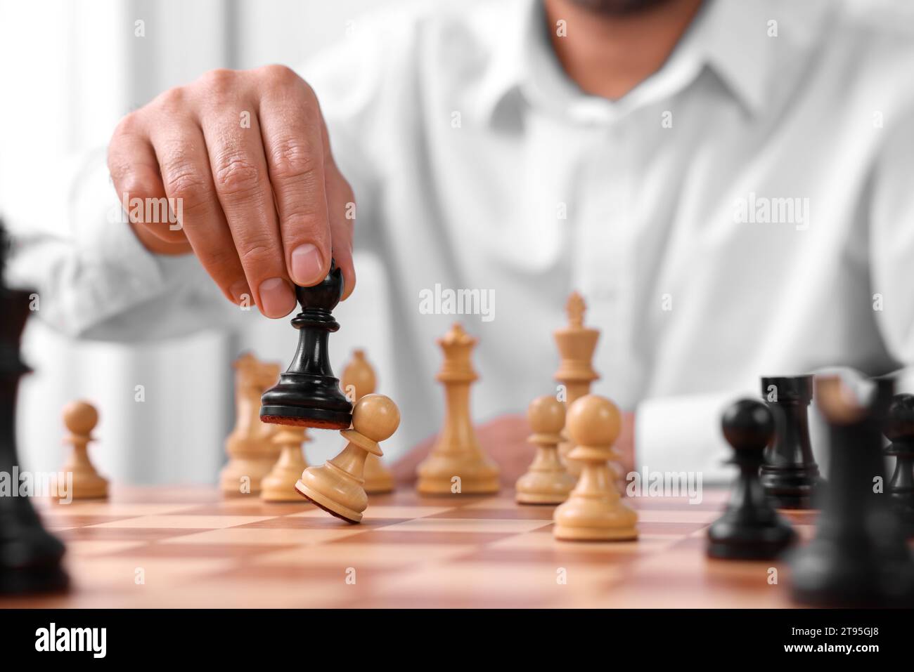 Man moving king chess piece at checkerboard indoors, closeup Stock ...