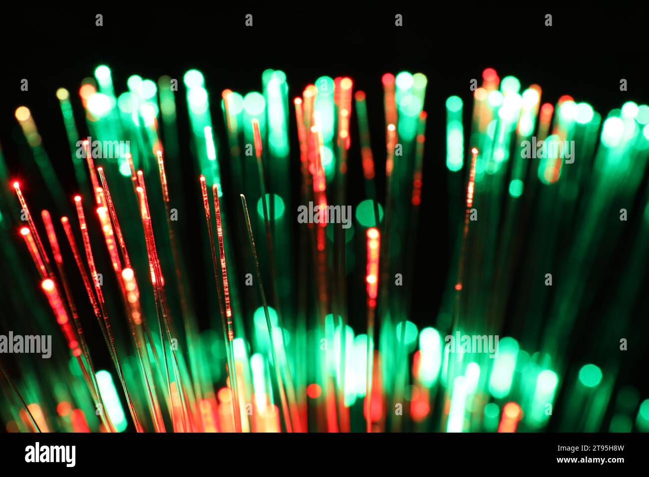 Optical fiber strands transmitting different color lights on black ...
