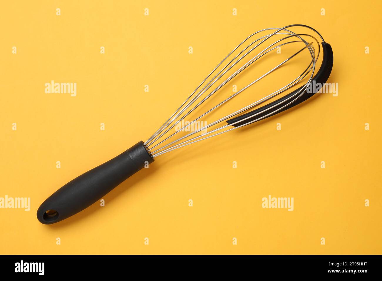 Metal whisk on yellow background, top view. Kitchen tool Stock Photo ...
