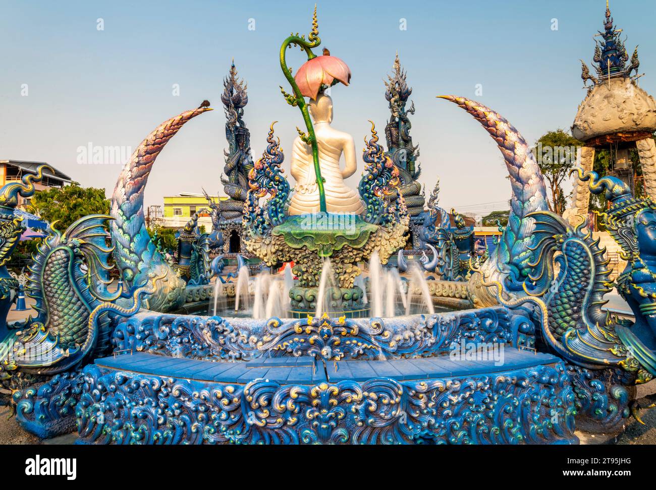 Aqua tiled pool with small fountains,at sunset,surrounded by decorative ...