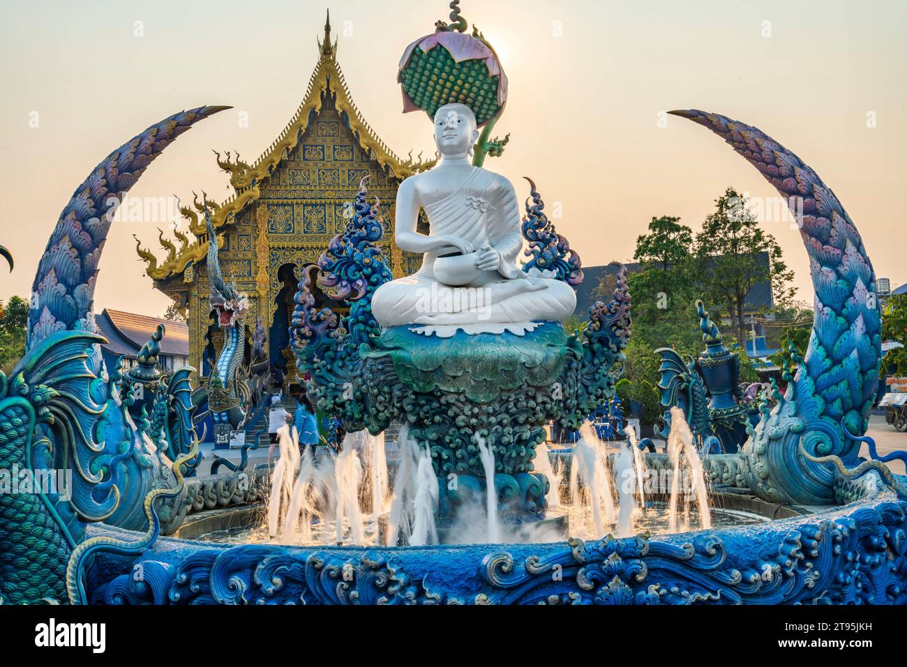 Aqua tiled pool with small fountains,at sunset,surrounded by decorative ...