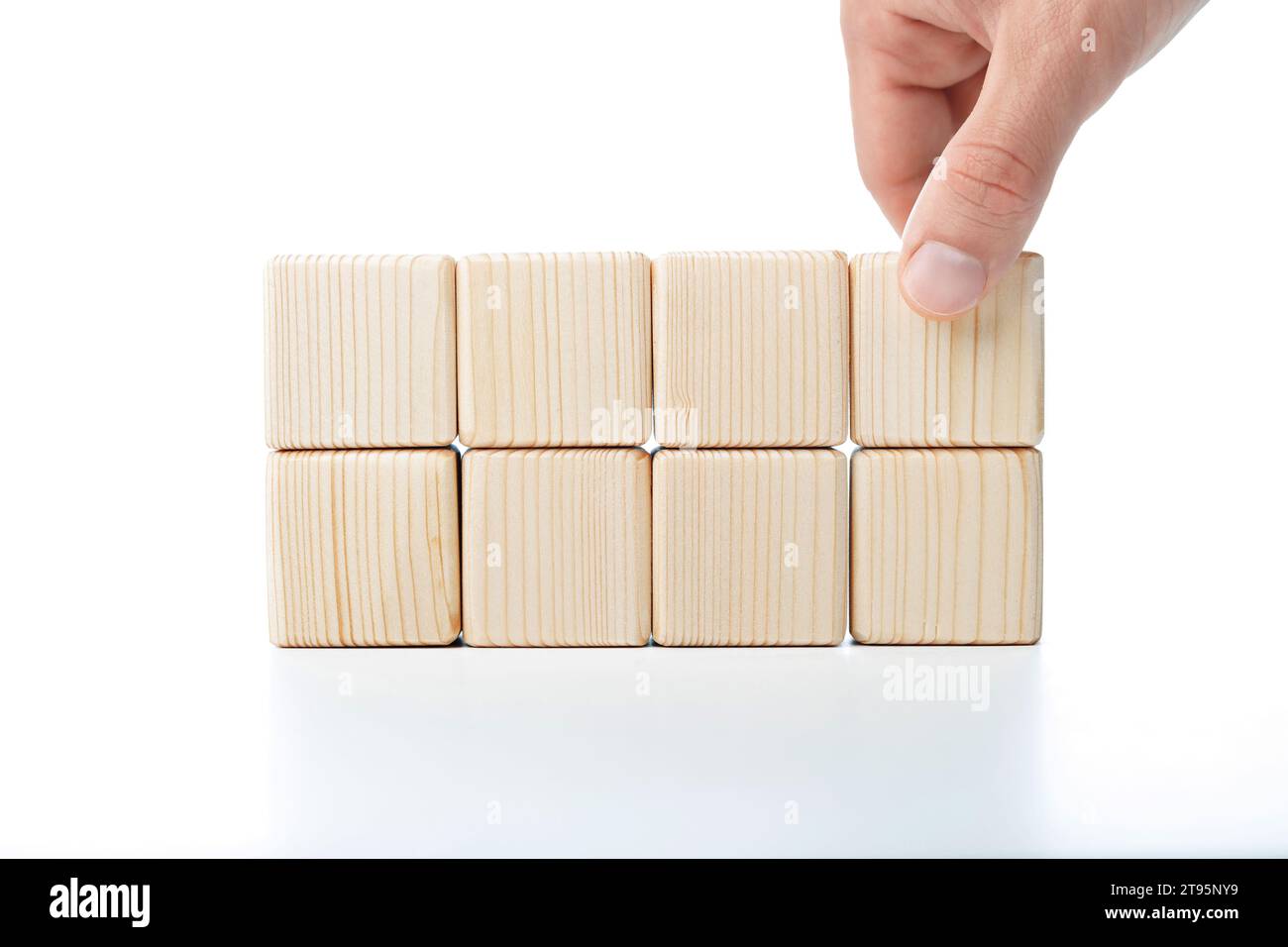 Hand putting and stacking blank wooden cubes on table with copy space ...