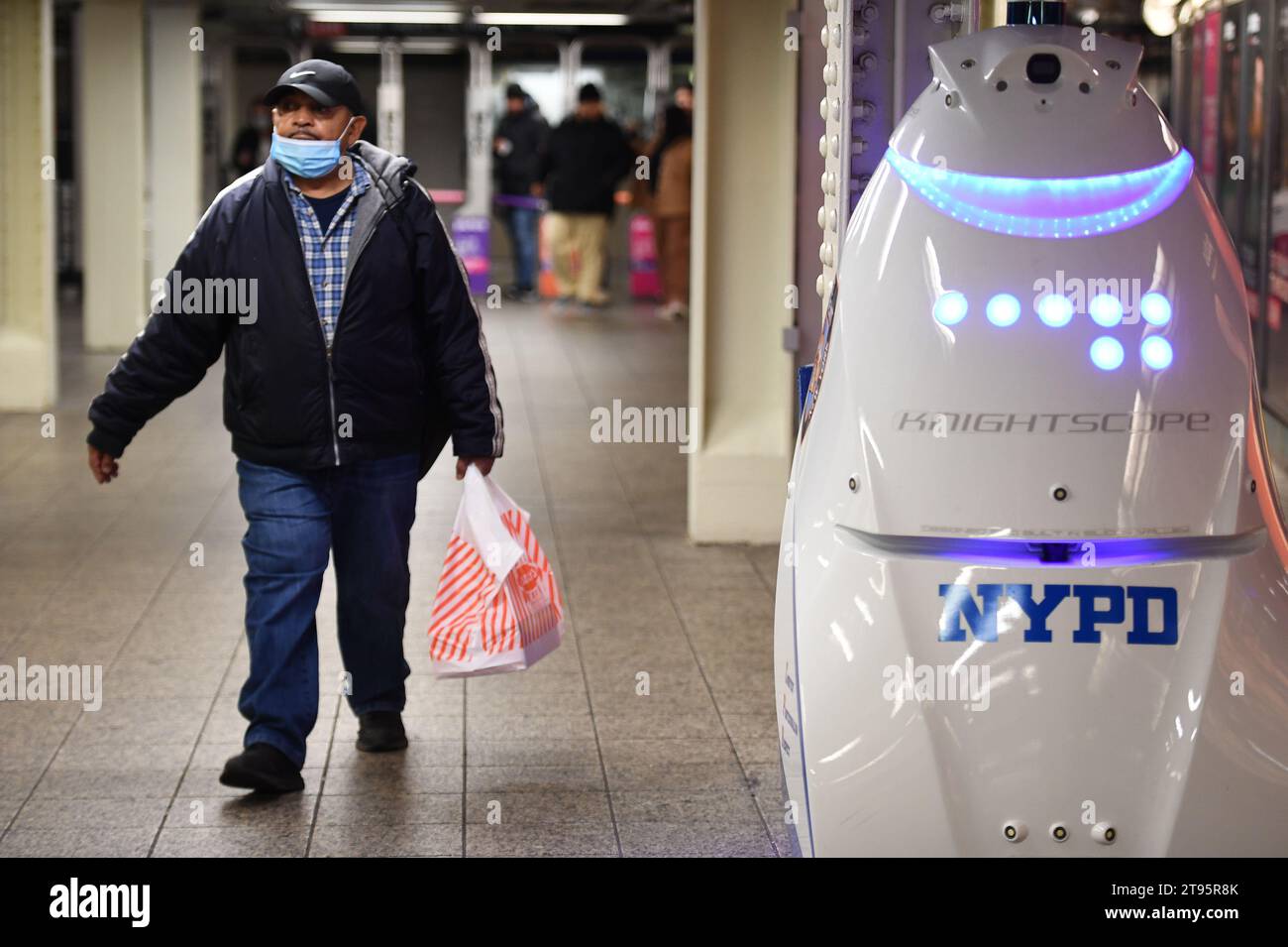 New York, USA. 22nd Nov, 2023. A commuter walks past the NYPD's Knightscope K5 Autonomous ...