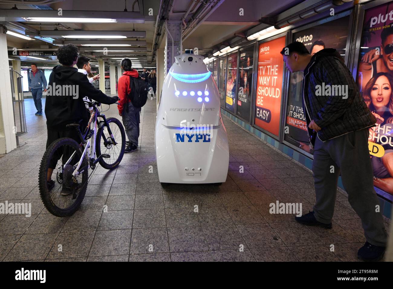 New York, USA. 22nd Nov, 2023. Commuters pause to look at the NYPD's Knightscope K5 Autonomous ...