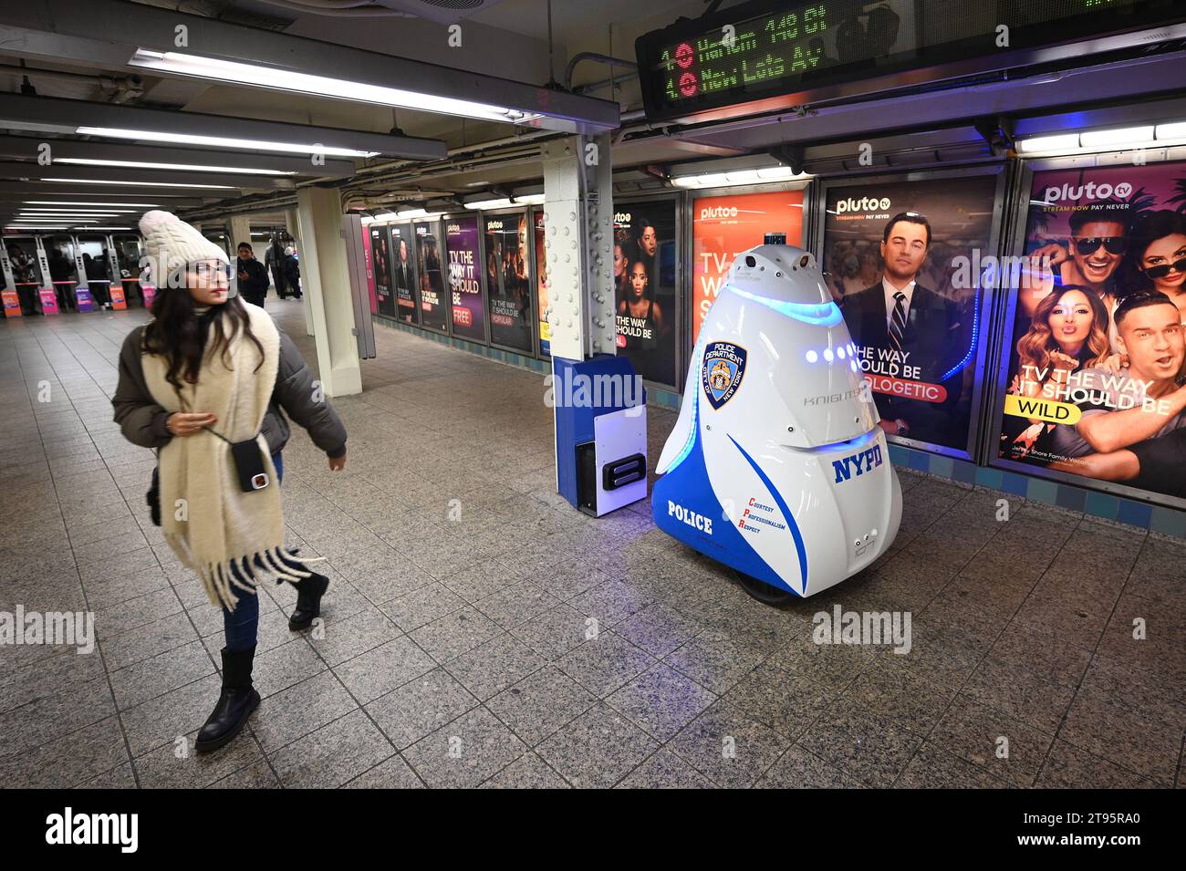 New York, USA. 22nd Nov, 2023. A woman walks past the NYPD's Knightscope K5 Autonomous Security ...