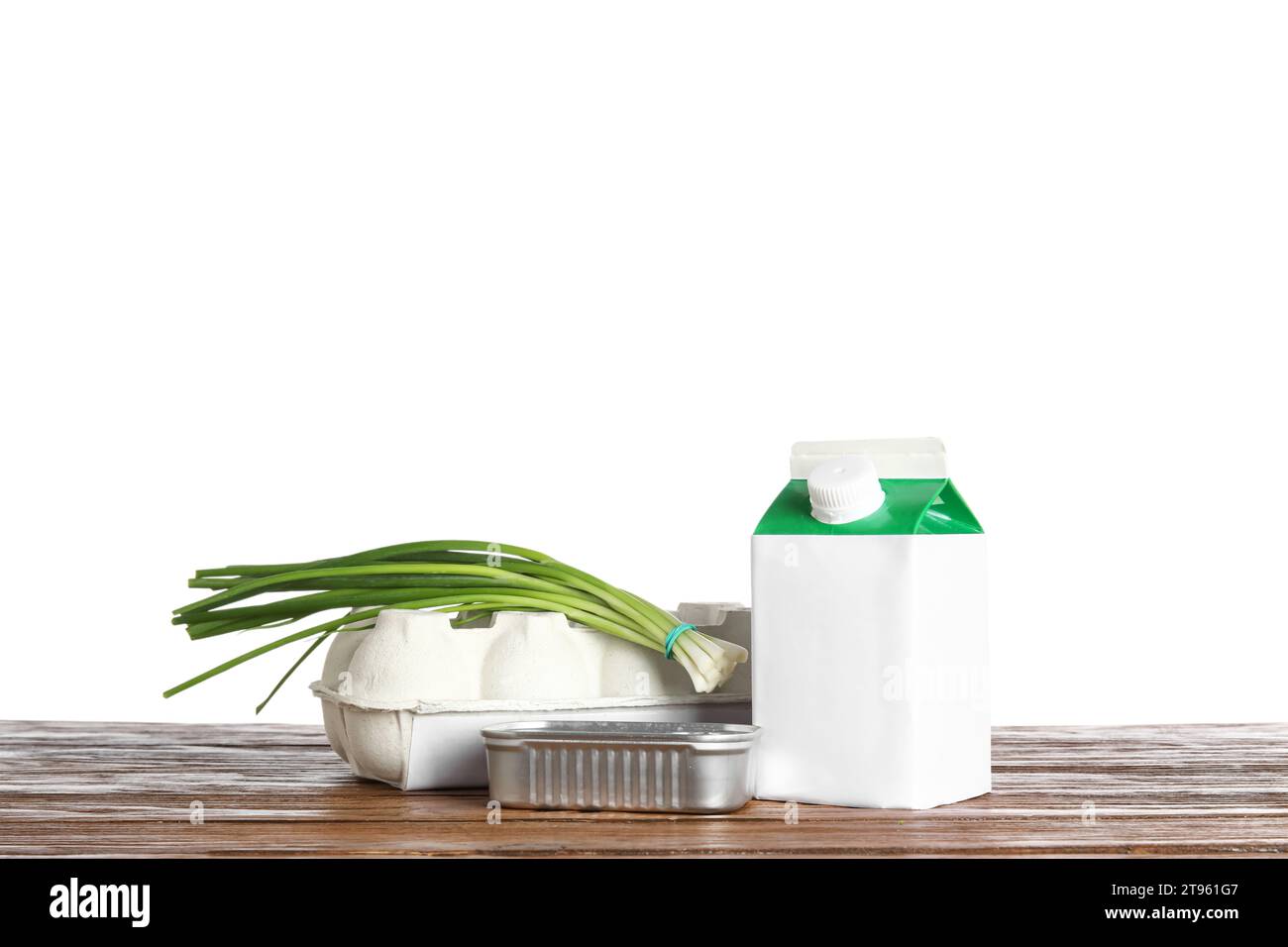 Board with fresh food on brown wooden kitchen table against white ...